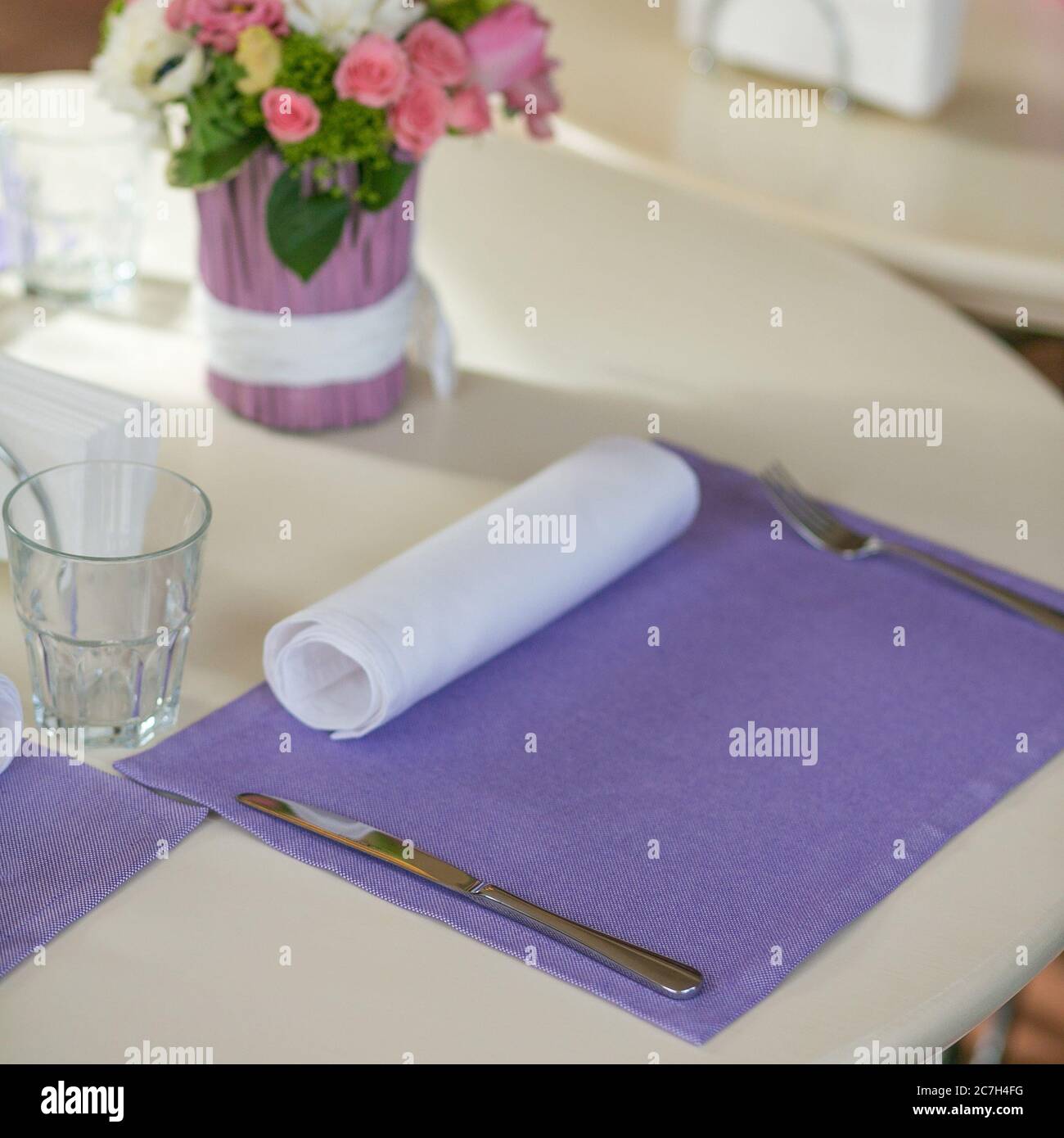 Purple napkin on dining table with flowers on blurred background ...