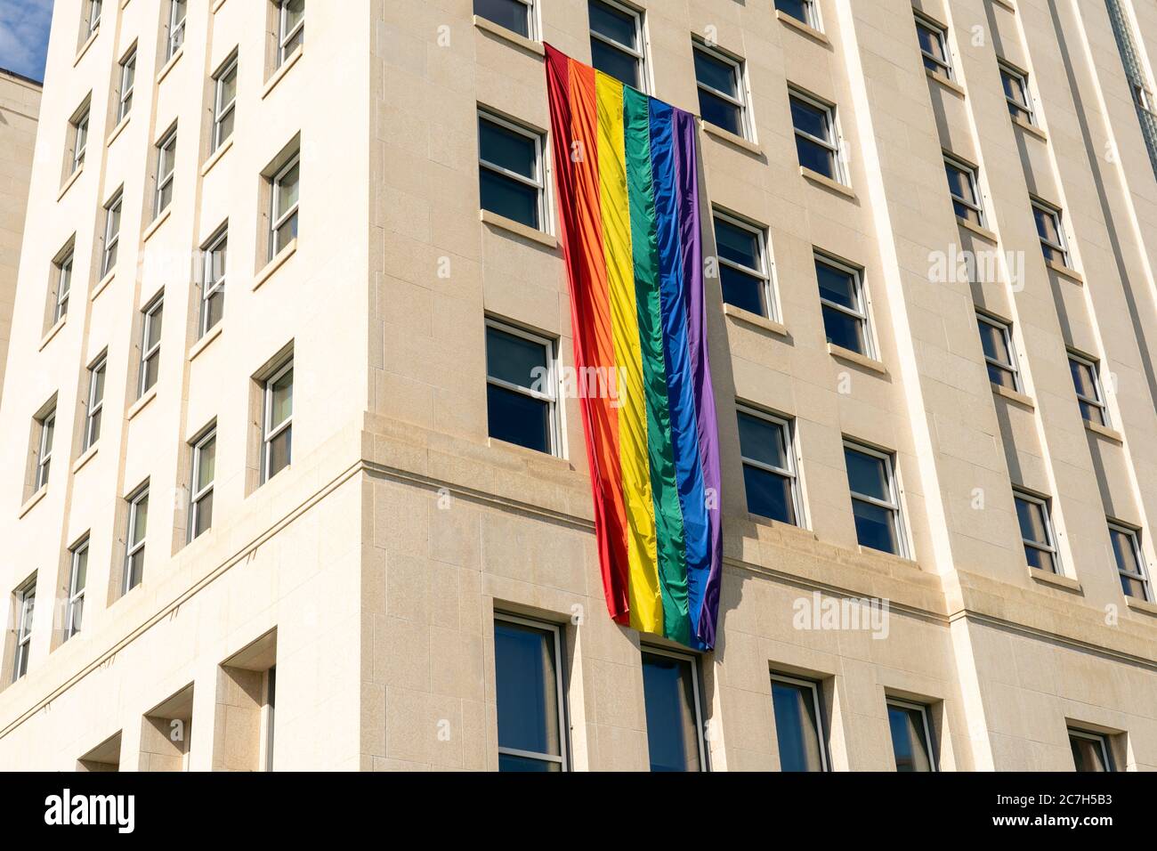 A huge rainbow flag is hanging on the building in a liberal city.A big ...