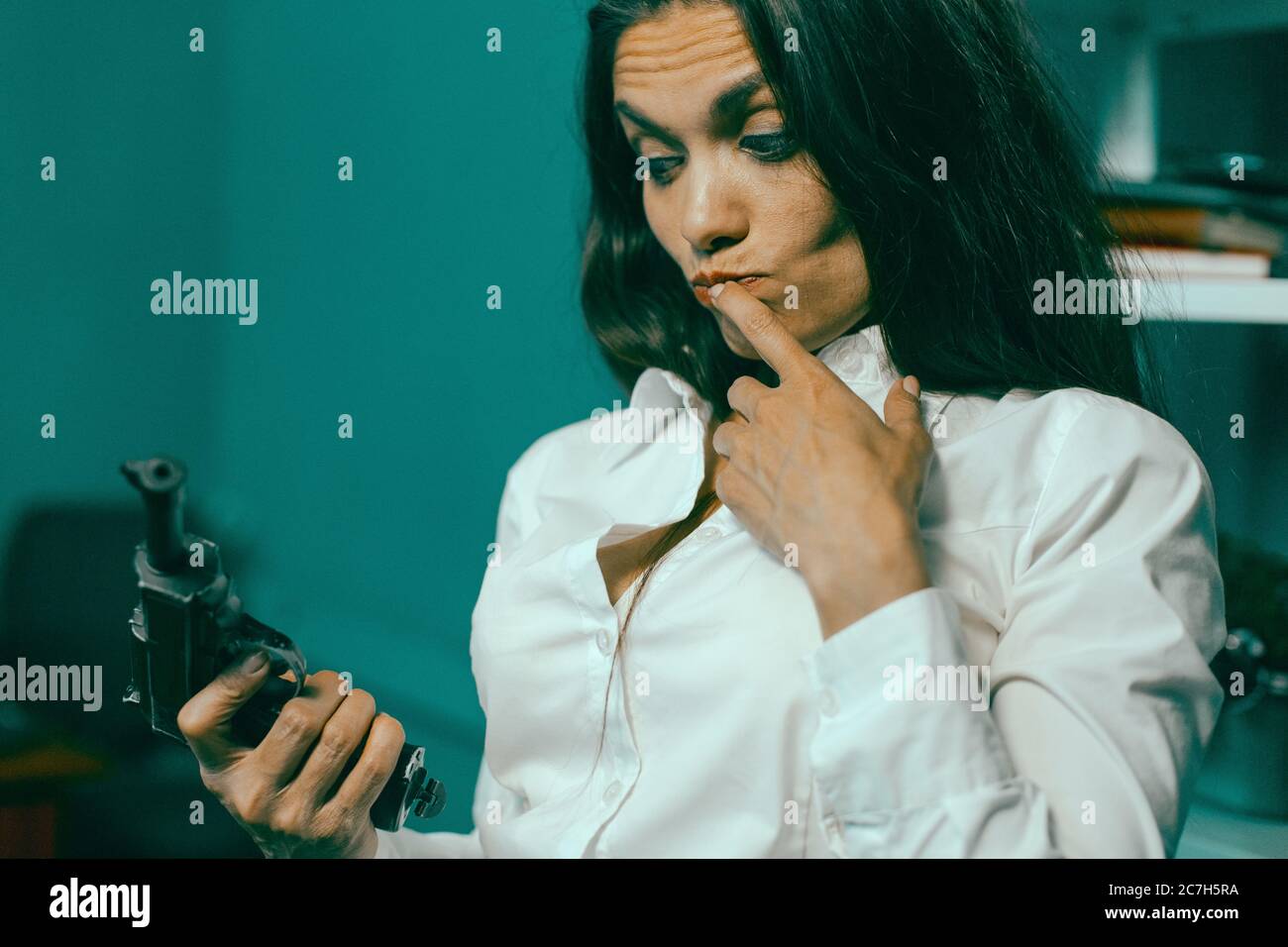 Crazy business woman with gun in office. Young beauty brunette holding ...