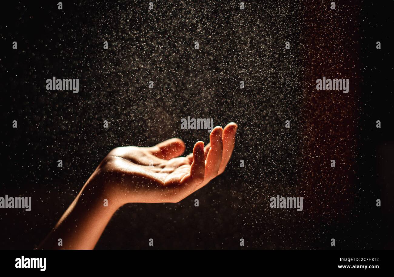 Hand reaching into a sparkling mist against a black background Stock ...