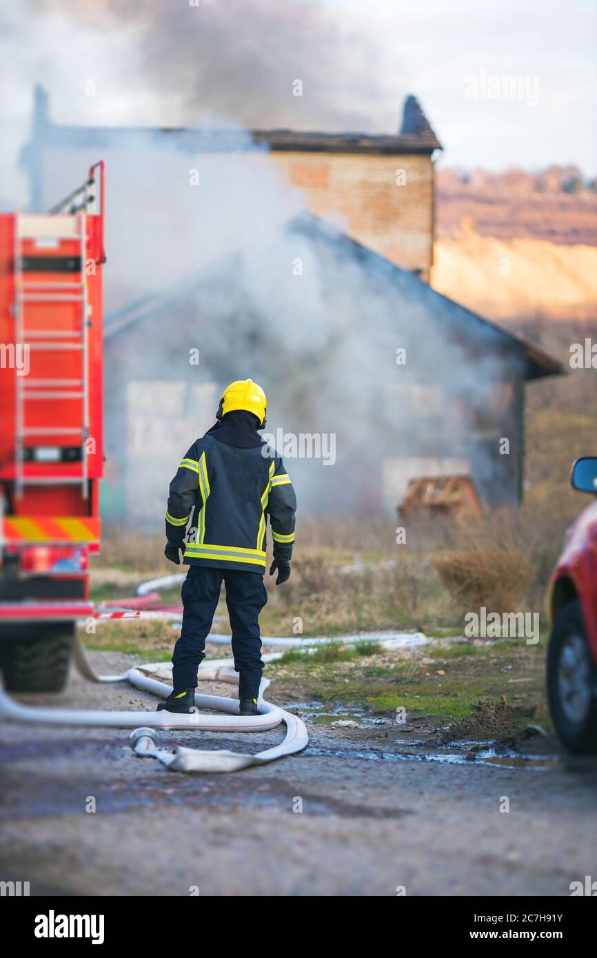 fireman rescuing a burning house Stock Photo - Alamy