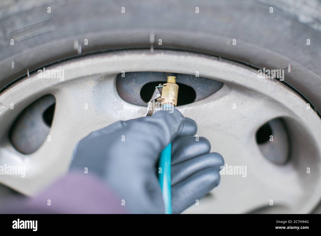 inflating car tire with air compression pump Stock Photo - Alamy