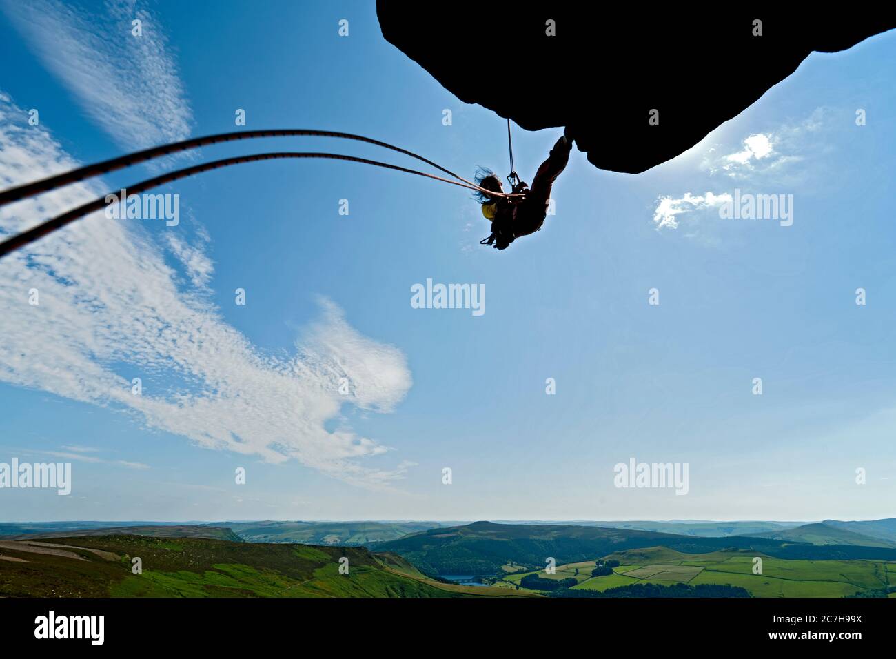 woman rappelling from cliff at Windgather rocks in the Peak District ...