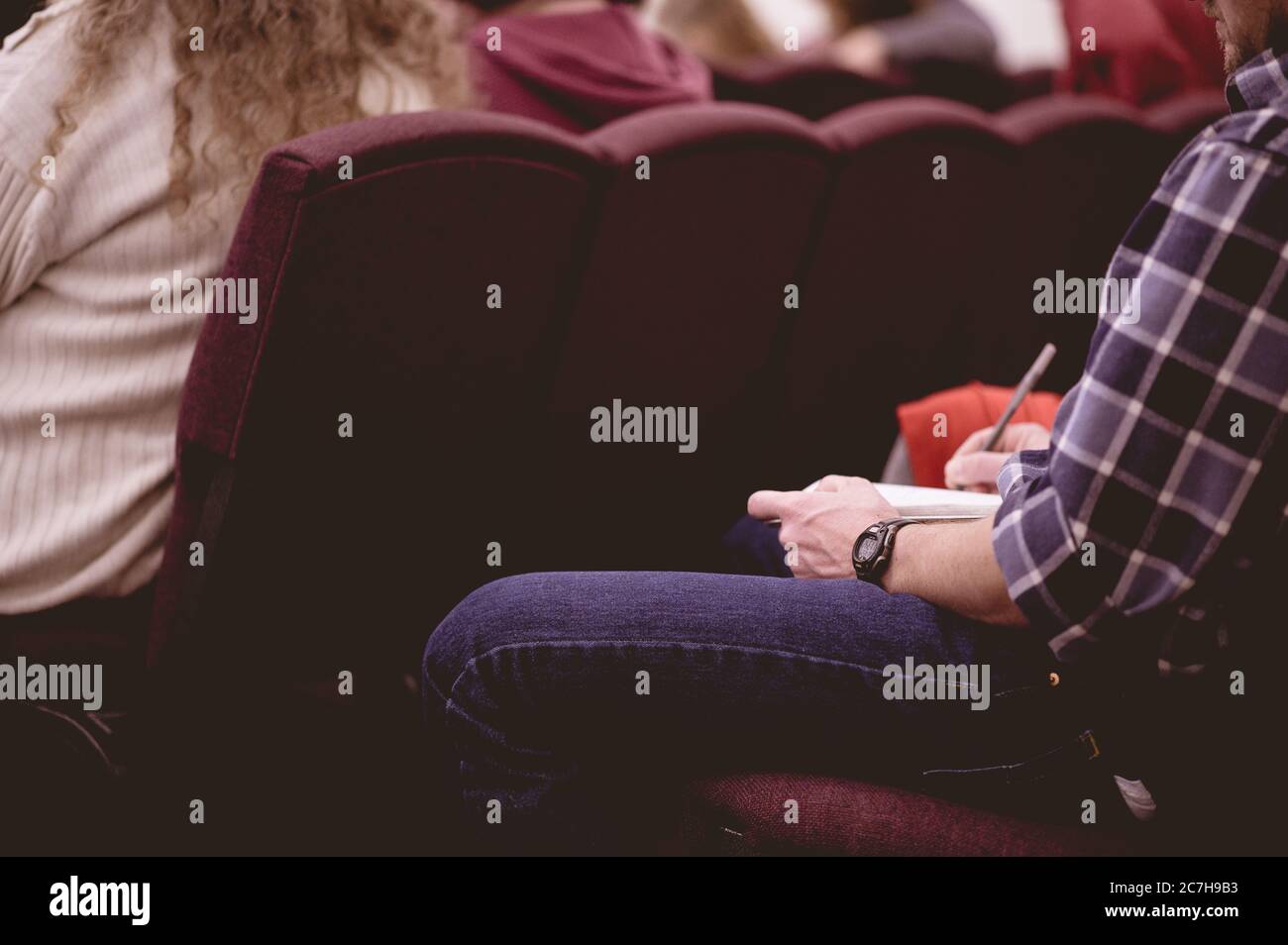Male wearing a flannel shirt writing something in his notebook Stock ...
