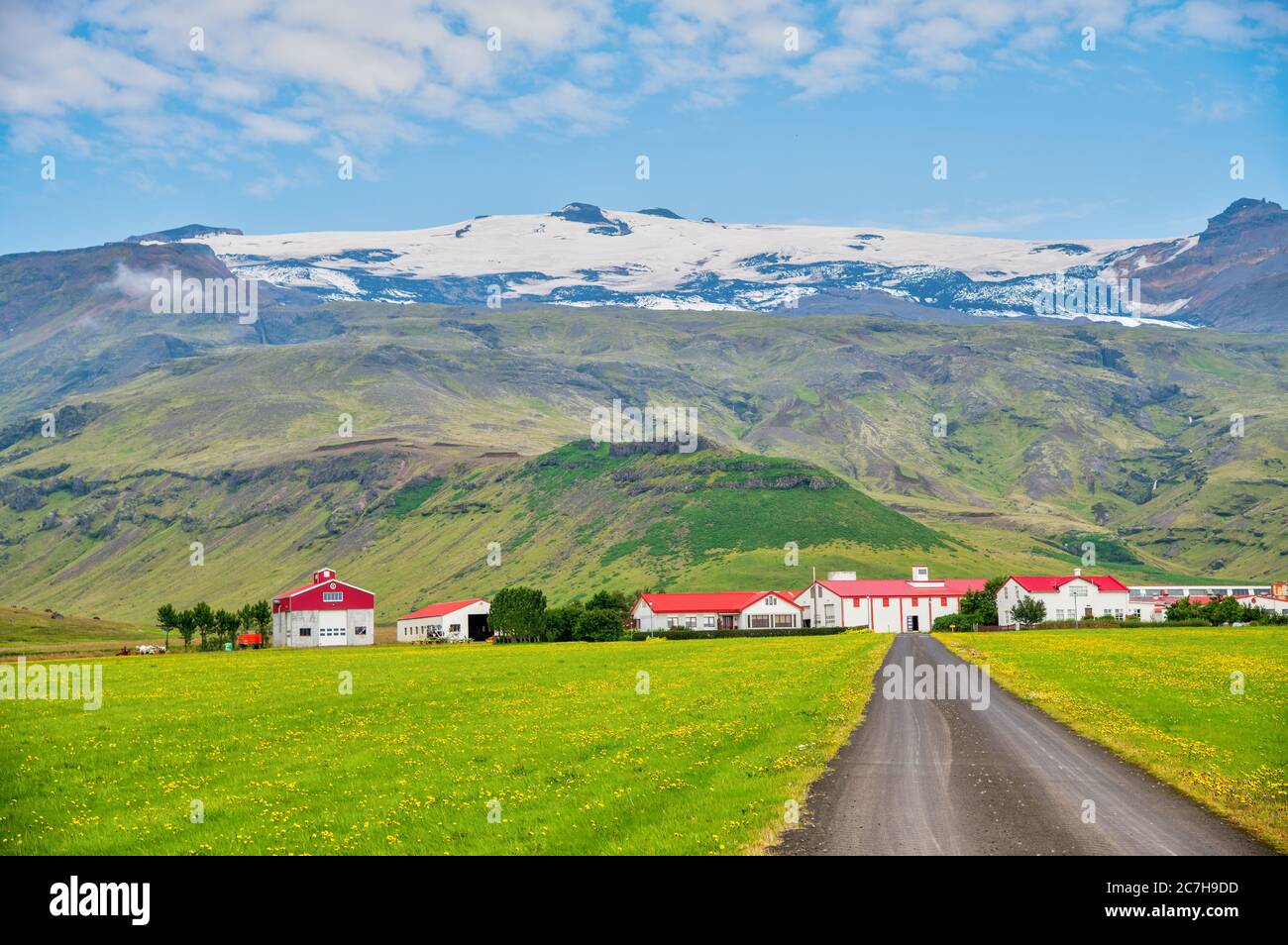 Icelandic countryside road with mountains and colorful homes at the end ...