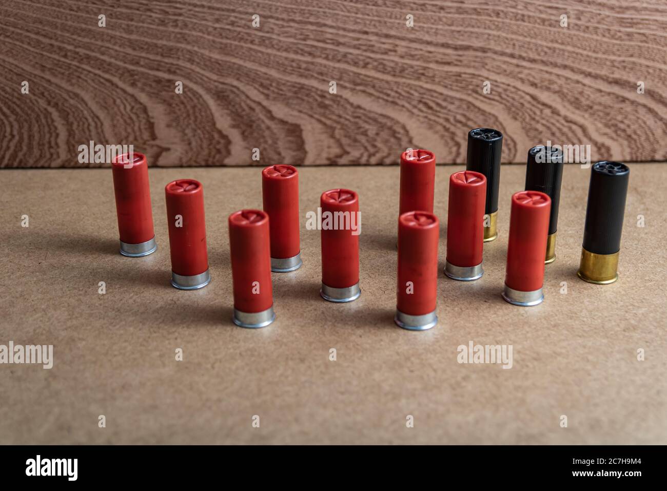 Closeup shot of red and black shotgun shells on a brown surface Stock ...