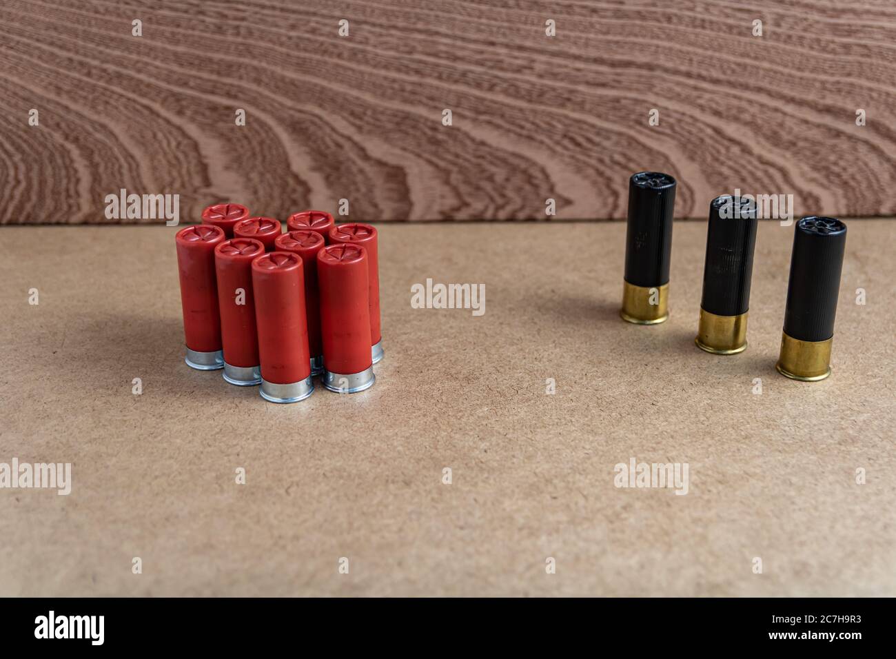 Selective focus shot of red shotgun shells near three black shotgun ...