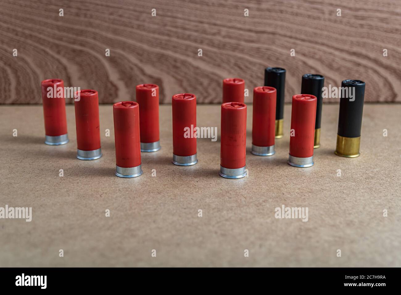 Selective focus shot of red and black shotgun shells on a brown surface ...