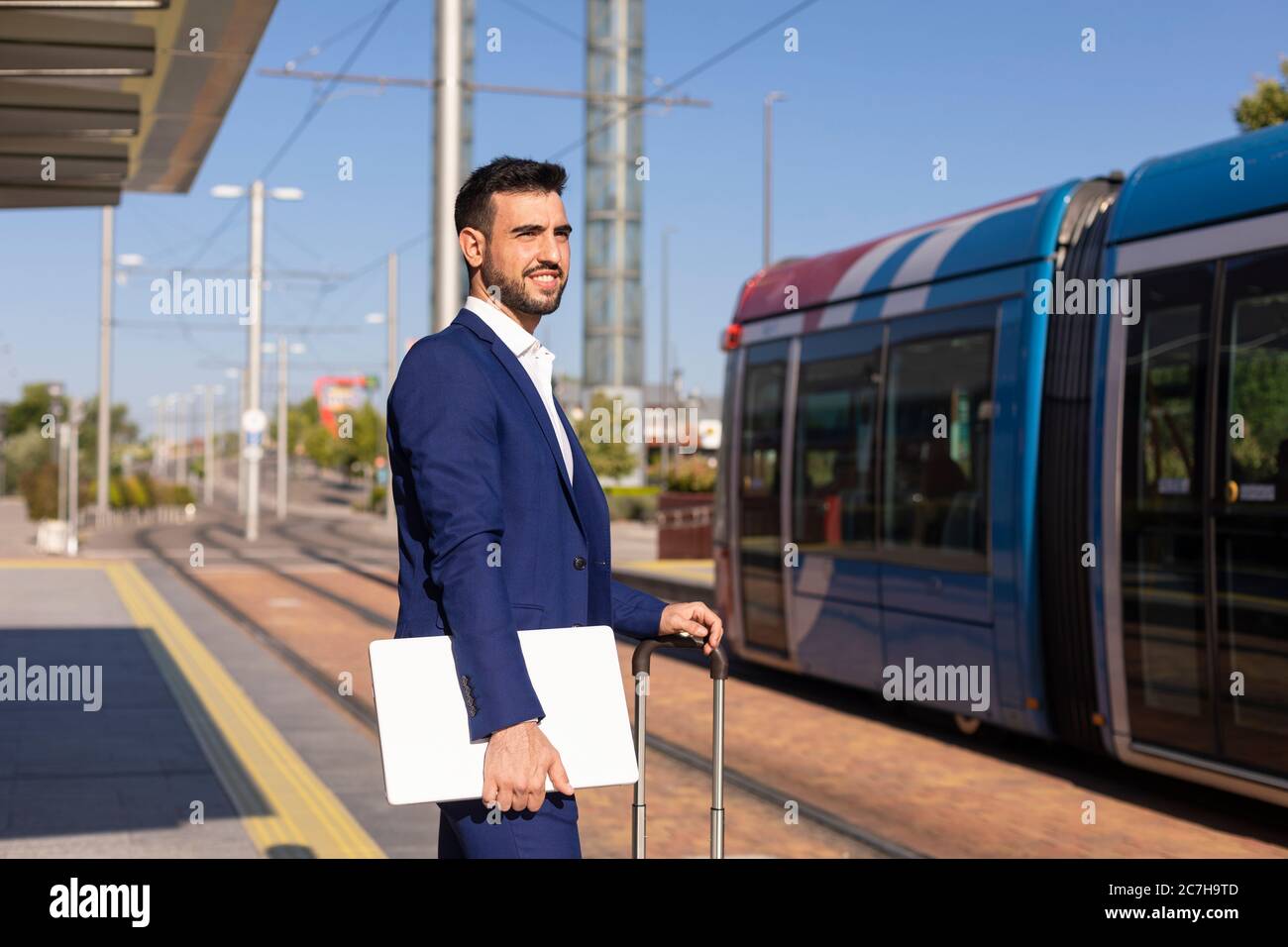 Young man in suit waiting at the train station Stock Photo - Alamy