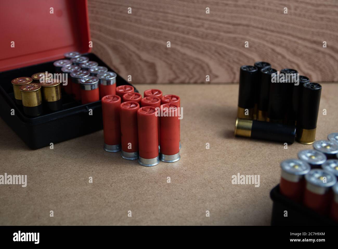 High angle shot of red and black shotgun shells near an ammo box on a ...
