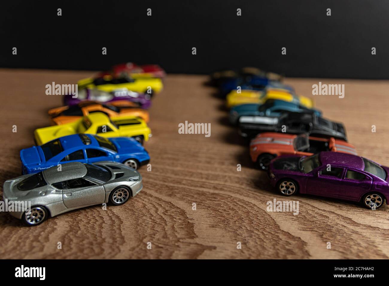 Selective focus shot of toy sports cars in a line on a wooden surface ...