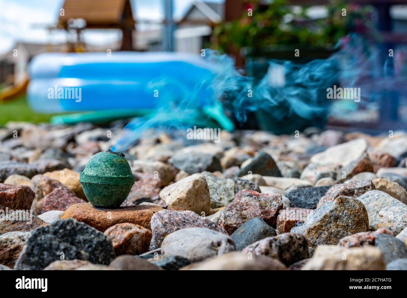 Low level view of a smoke bomb being lit and shooting smoke out the top ...