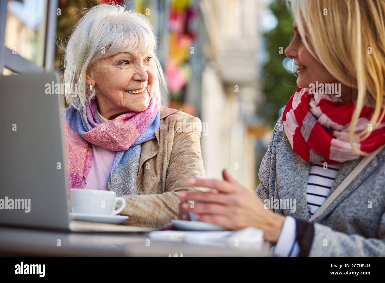 Conversation of two beautiful women in street cafe Stock Photo - Alamy