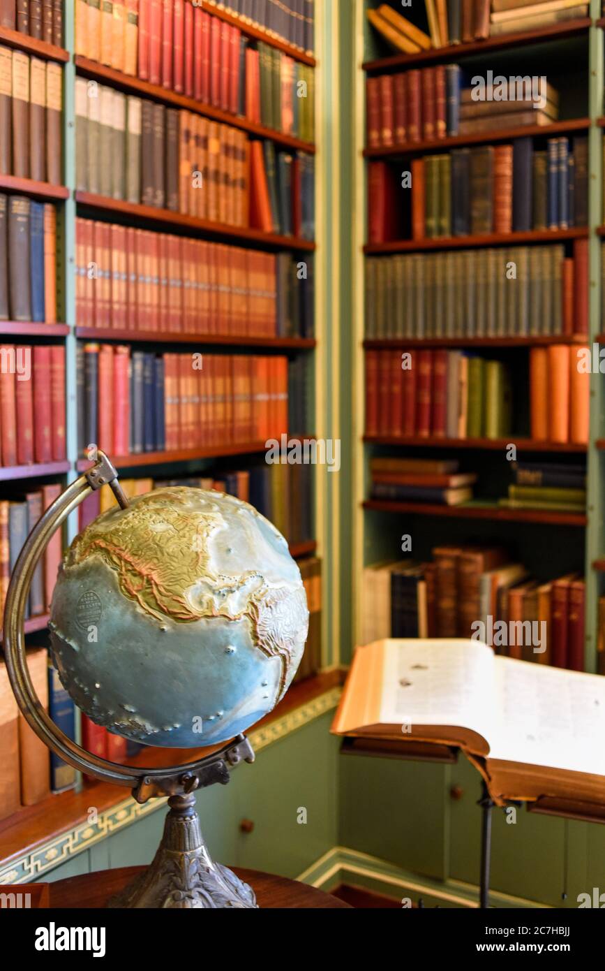 An office library with a globe of the world on a desk Stock Photo - Alamy