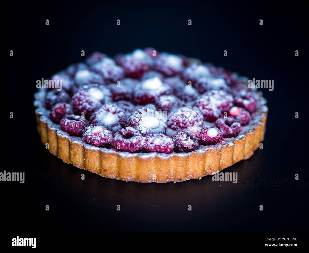 Closeup shot of a red berry pie on a black surface Stock Photo - Alamy