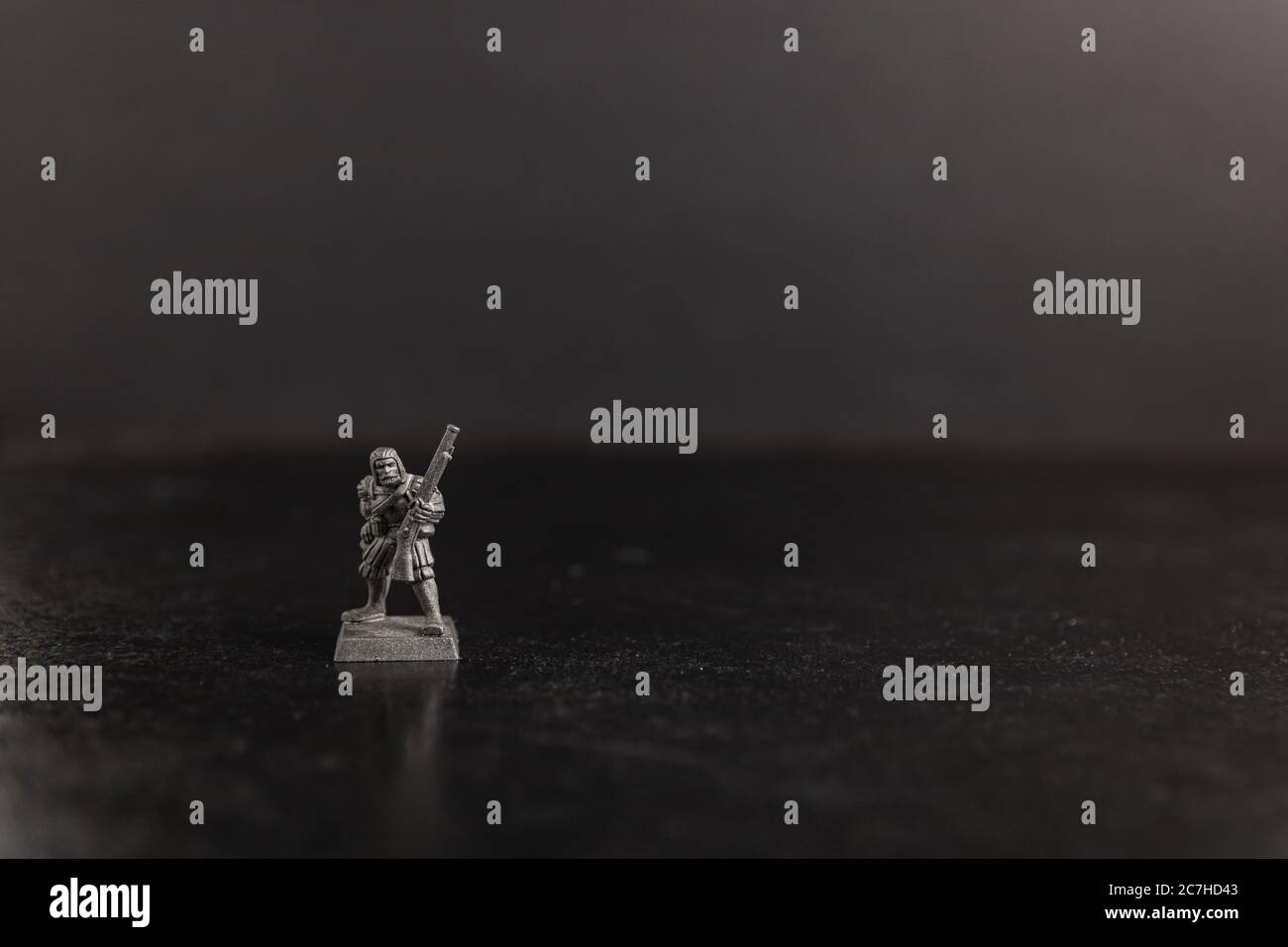 Selective focus grayscale shot of a soldier holding a gun figurine ...