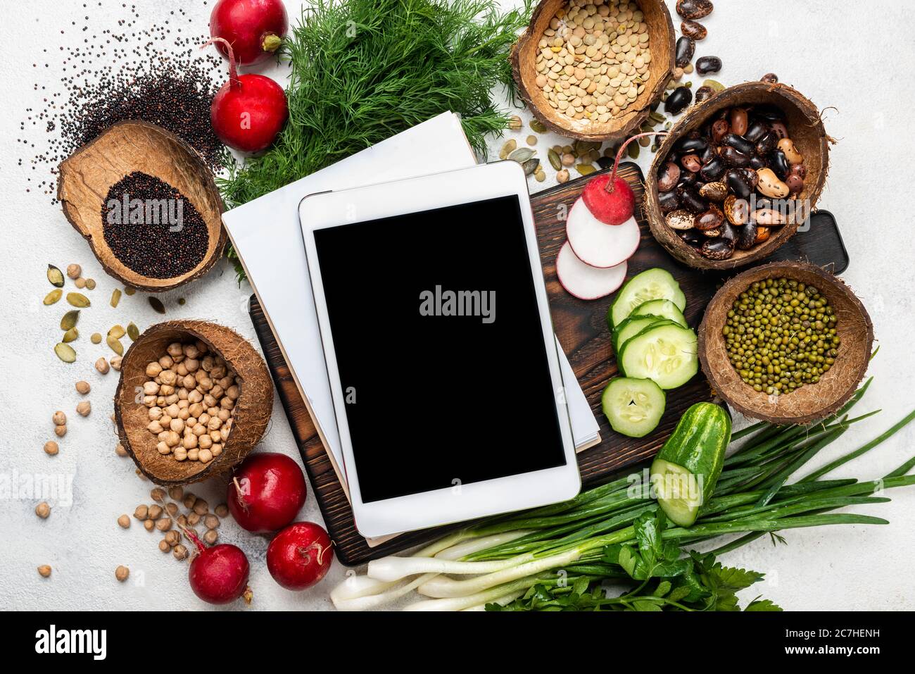 Tablet computer vegetables cereals greens beans on the chopping board ...