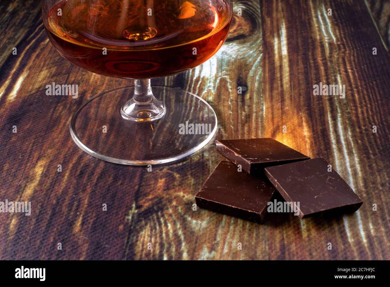 Glass with cognac and dark chocolate. Dear elite alcohol on a dark ...