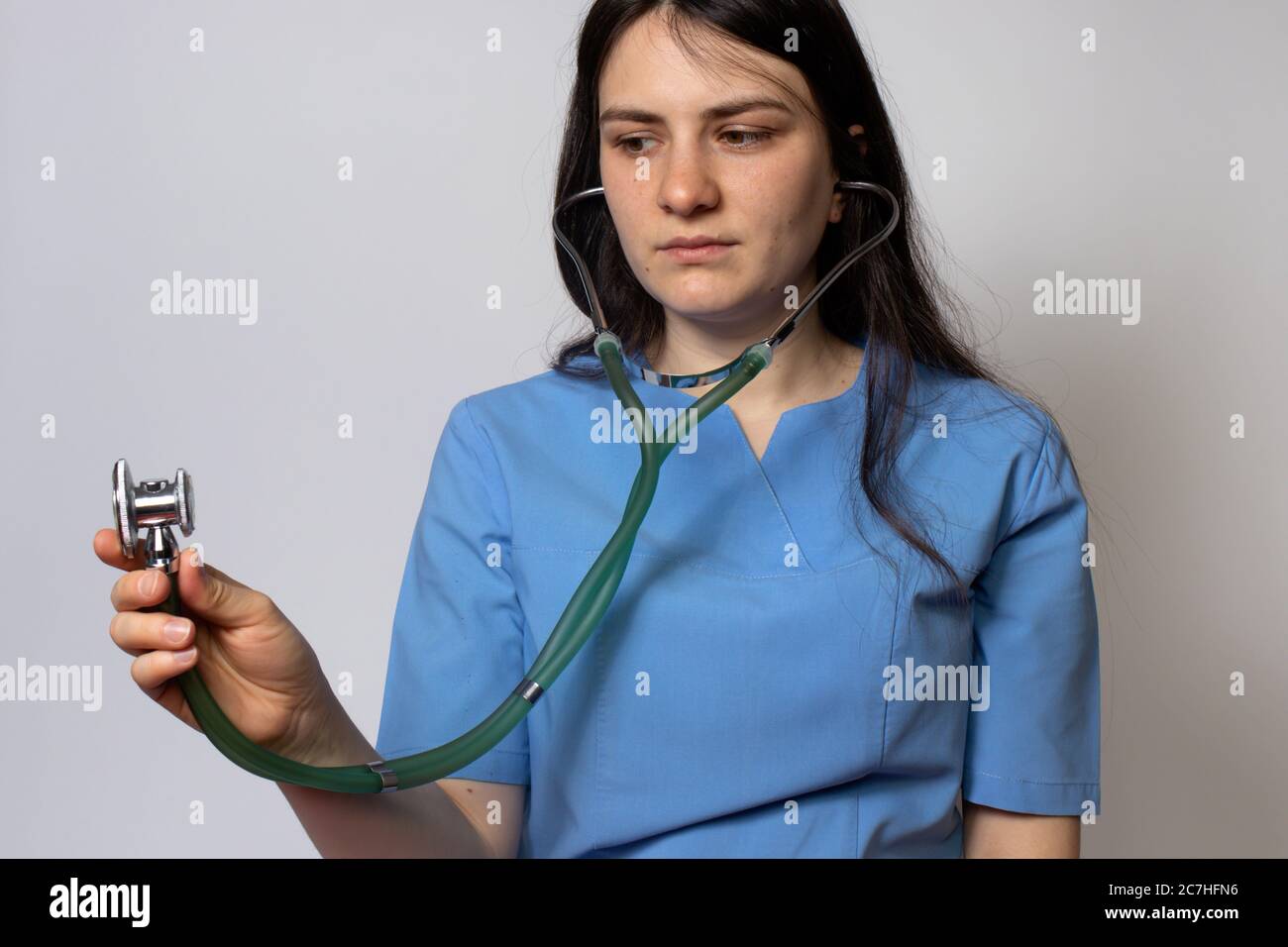 Doctor in blue uniform holds a stethoscope in his hand Stock Photo - Alamy