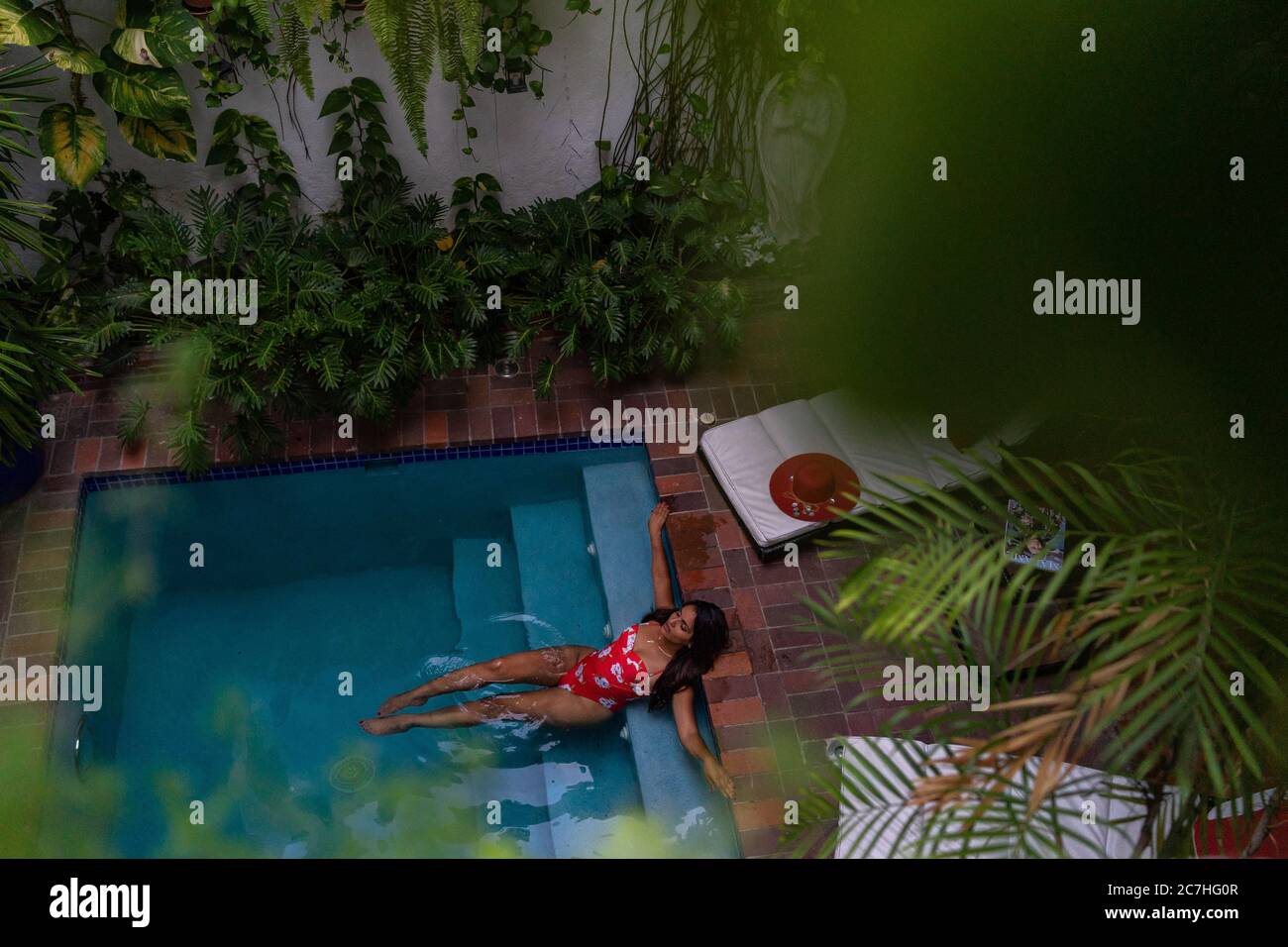 Woman leaning at the edge of swimming pool hi-res stock photography and ...