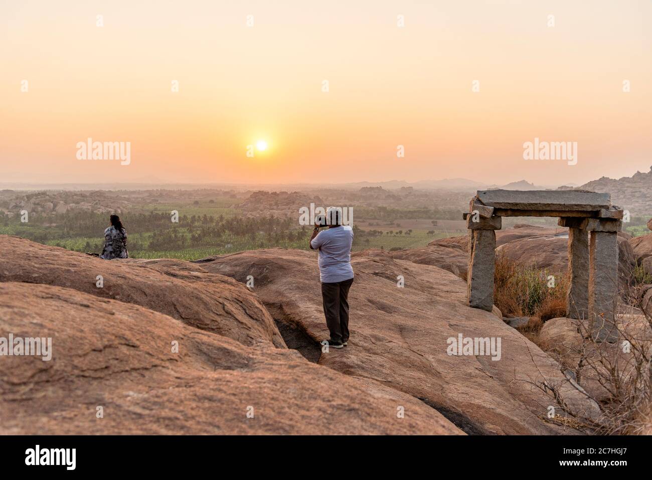 Group of people looking down into the valley at dusk Stock Photo - Alamy