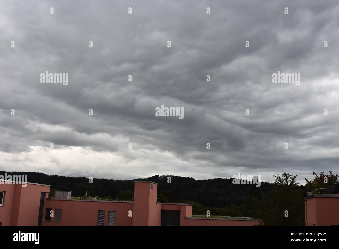 Heavy thunderstorm clouds bringing the rain above residential house in ...
