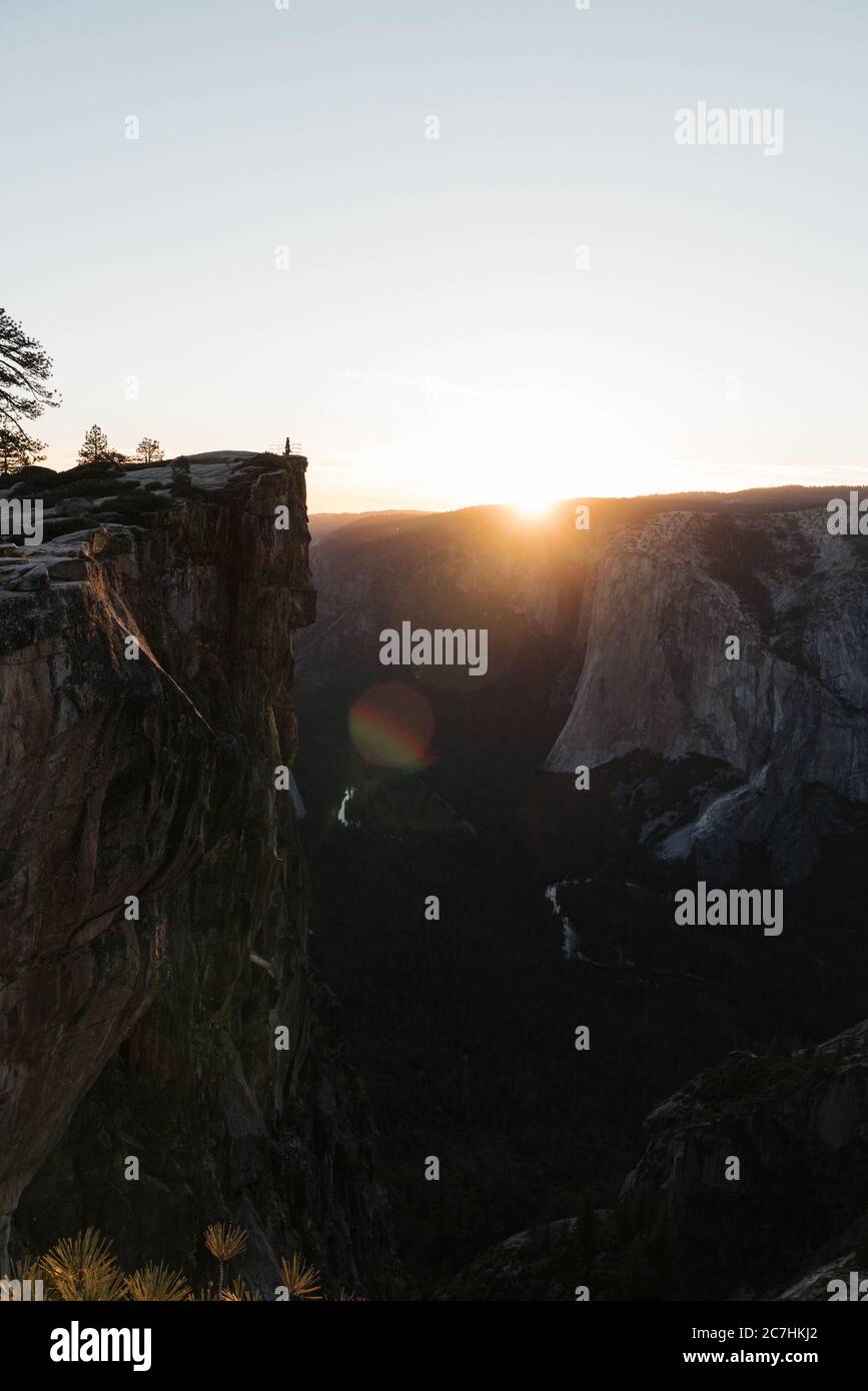Breathtaking scenery of the sun rising over a rock formation covered in ...