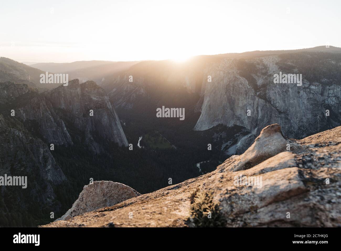 Breathtaking scenery of the sun rising over a rock formation covered in ...