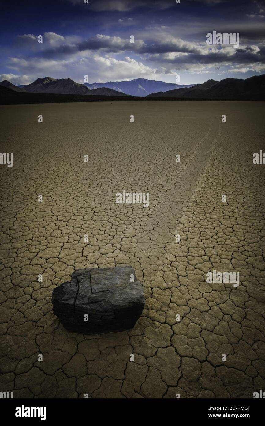 Vertical shot of a deserted ground of sand surrounded by a mountainous ...