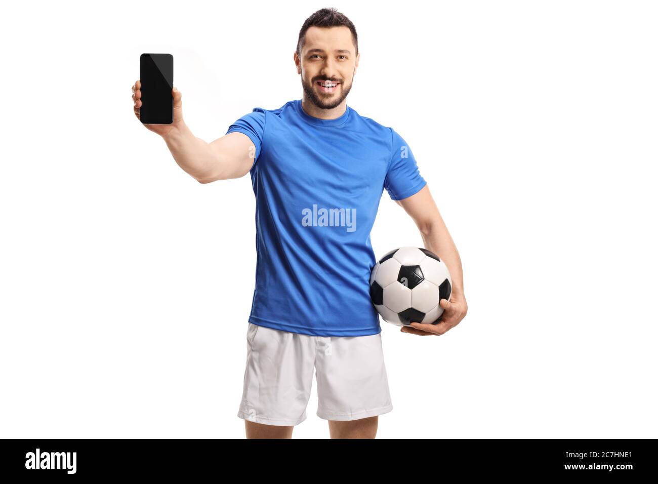 Soccer player holding a football and a mobile phone isolated on white ...