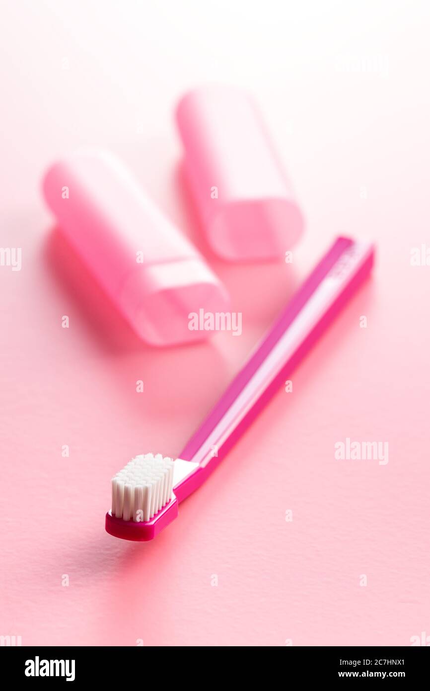 New pink toothbrush on pink background Stock Photo - Alamy