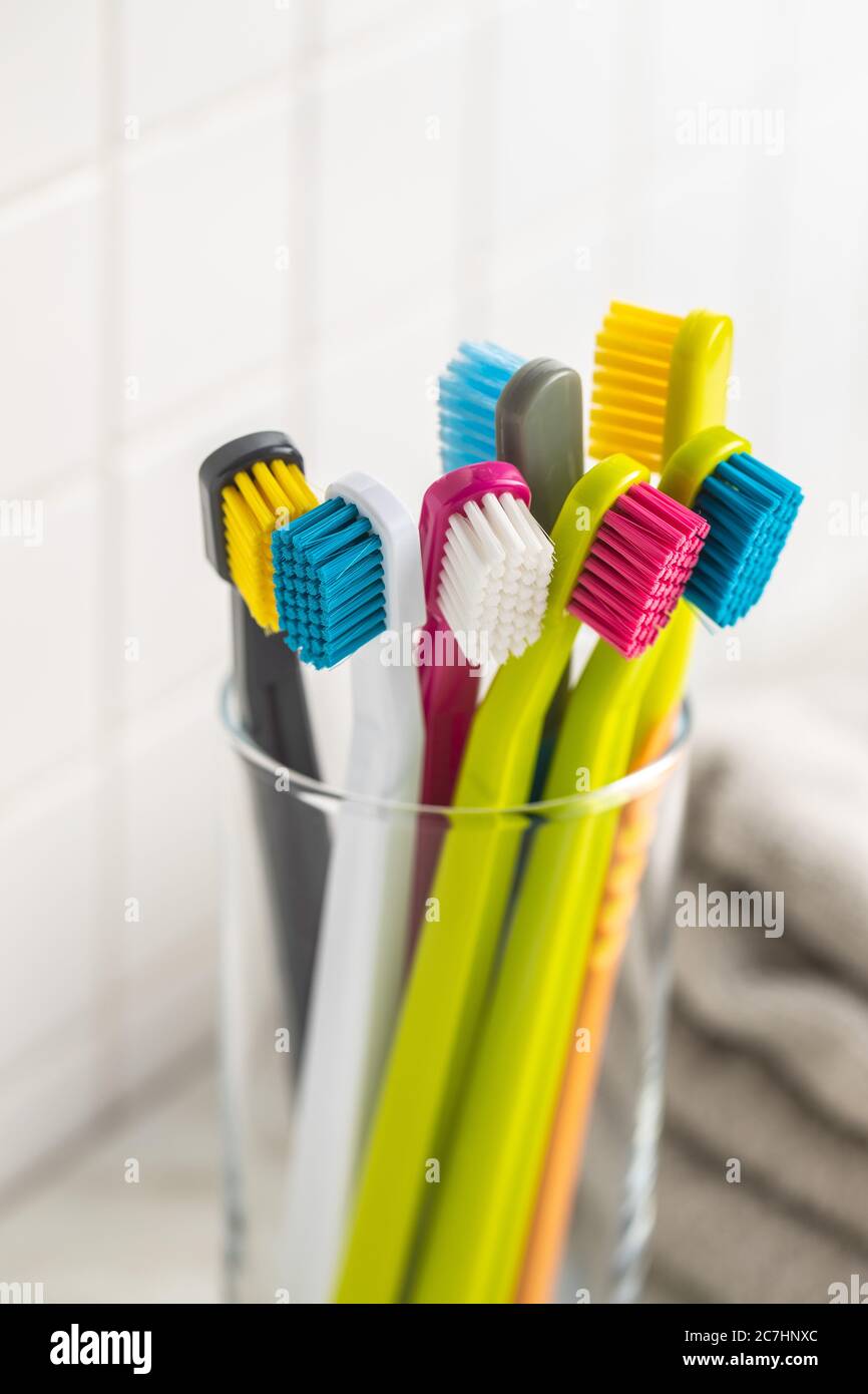 Various colorful toothbrushes in cup Stock Photo - Alamy