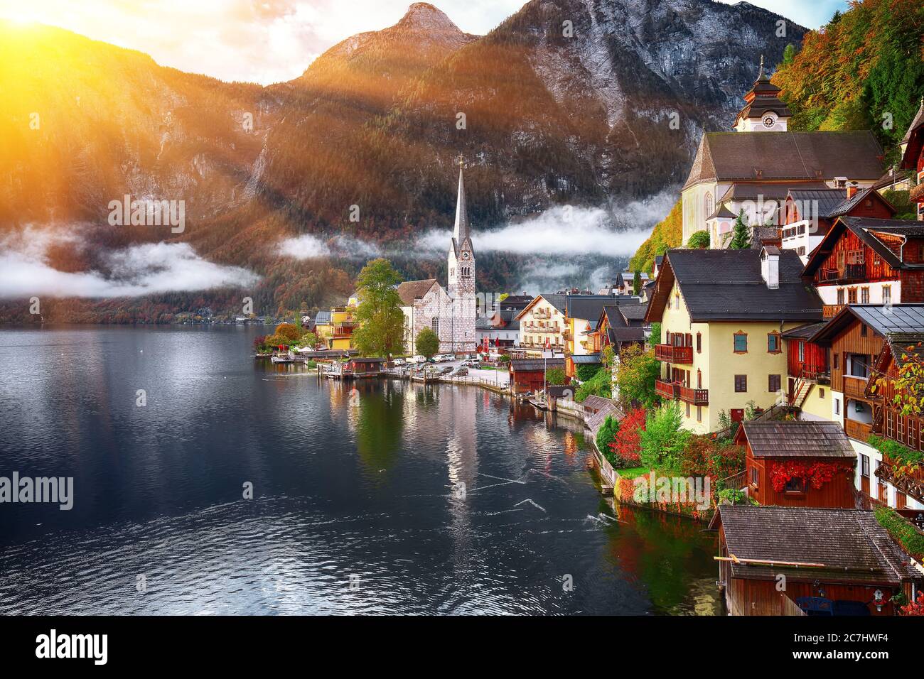 Scenic view of famous Hallstatt mountain village with Hallstatter lake. Foggy autumn sunrise on ...