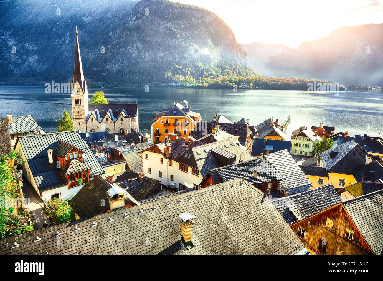 Scenic view of famous Hallstatt mountain village with Hallstatter lake. Sunny autumn sunrise on ...