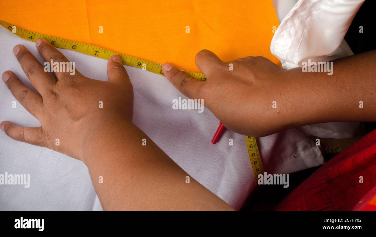 Tailor measuring garment on the table Stock Photo - Alamy