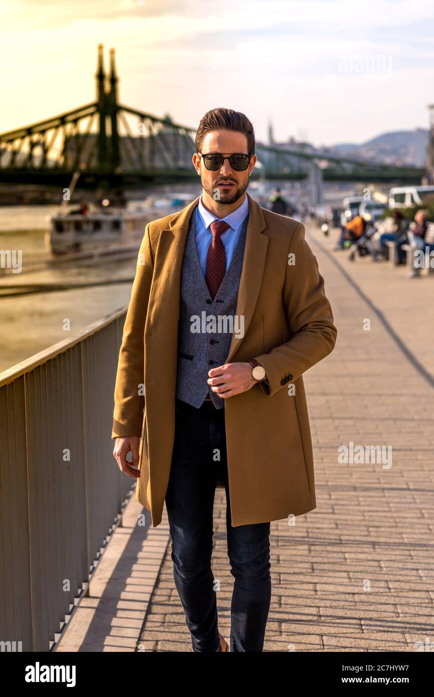 A handsome elegant man standing next to a river on a sunny day Stock ...
