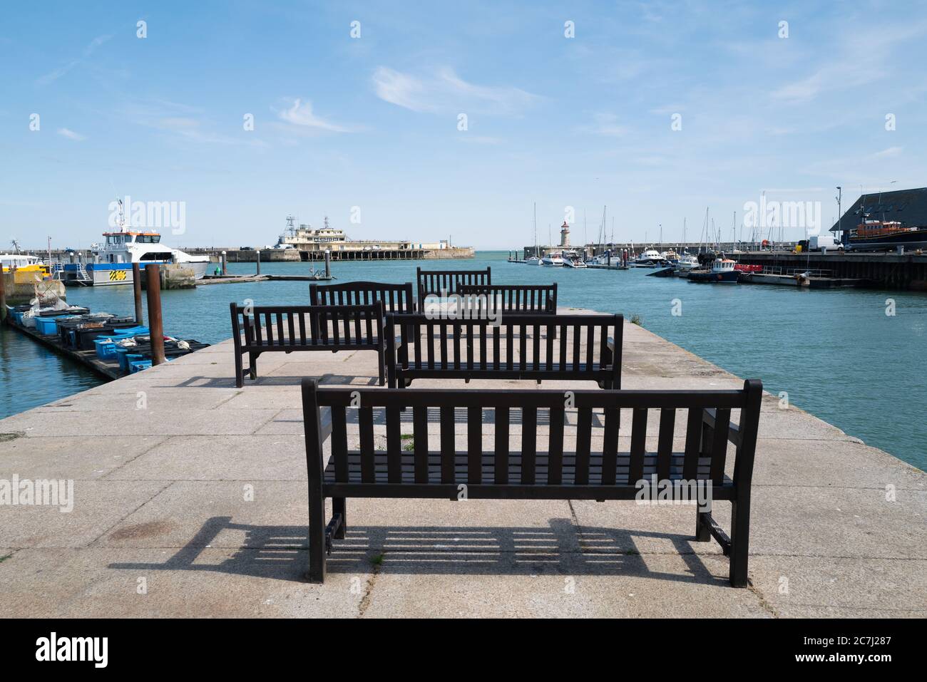 Wooden benches in the Royal Harbour, Ramsgate, looking out towards the ...