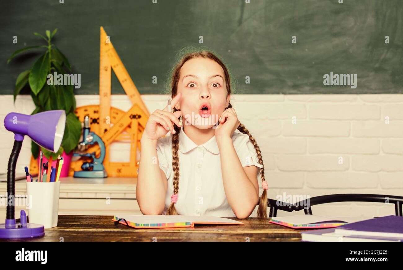 Girl cute child sit school classroom chalkboard background. Small kid study school. Knowledge ...