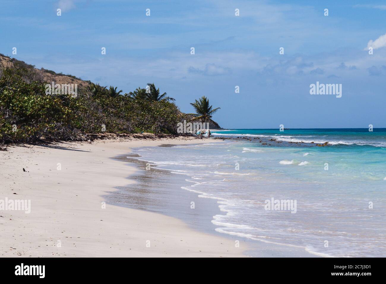 People walking off in the distance at Playa Zoni beach on a sunny day ...