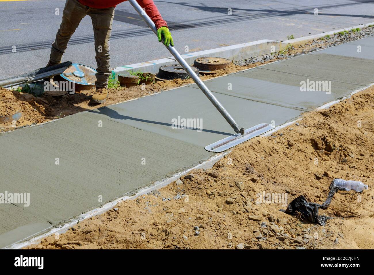 Laying down new sidewalk in wet concrete on freshly poured sidewalks ...