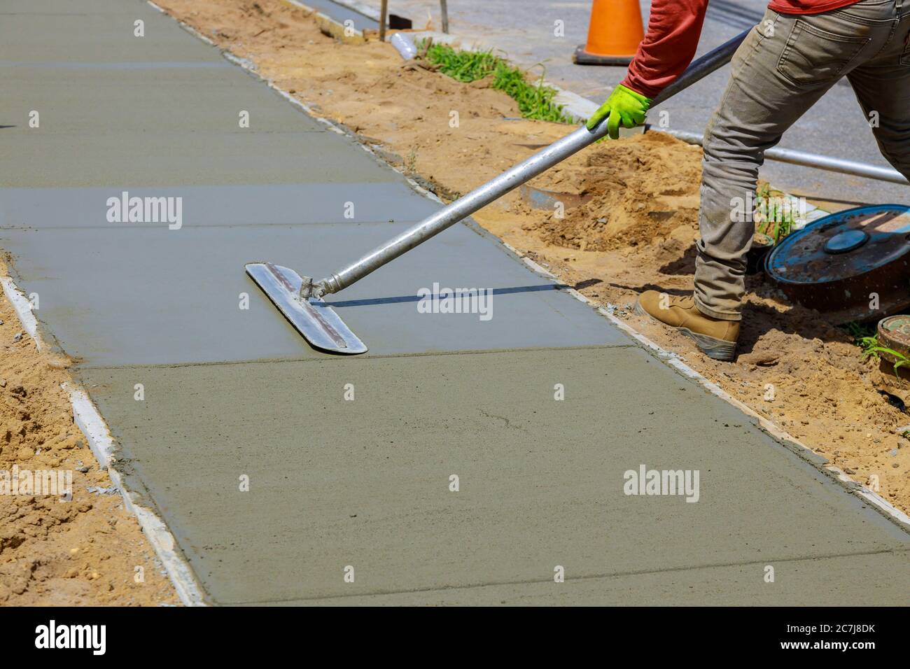 Construction mason building a screed coat cement a laborer floats a new ...