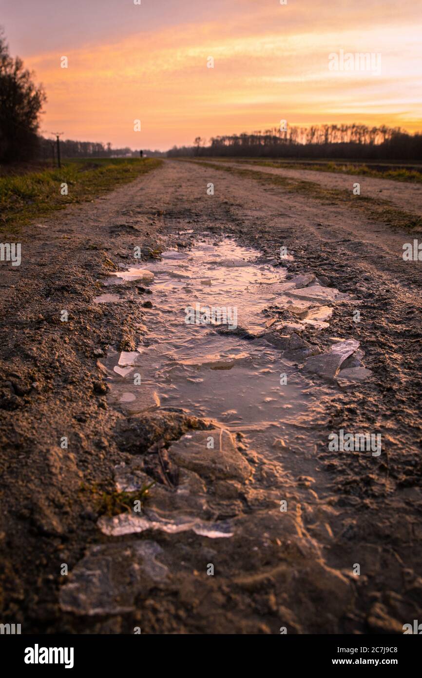 Vertical high angle shot of a small mud on the road in a rural area and ...