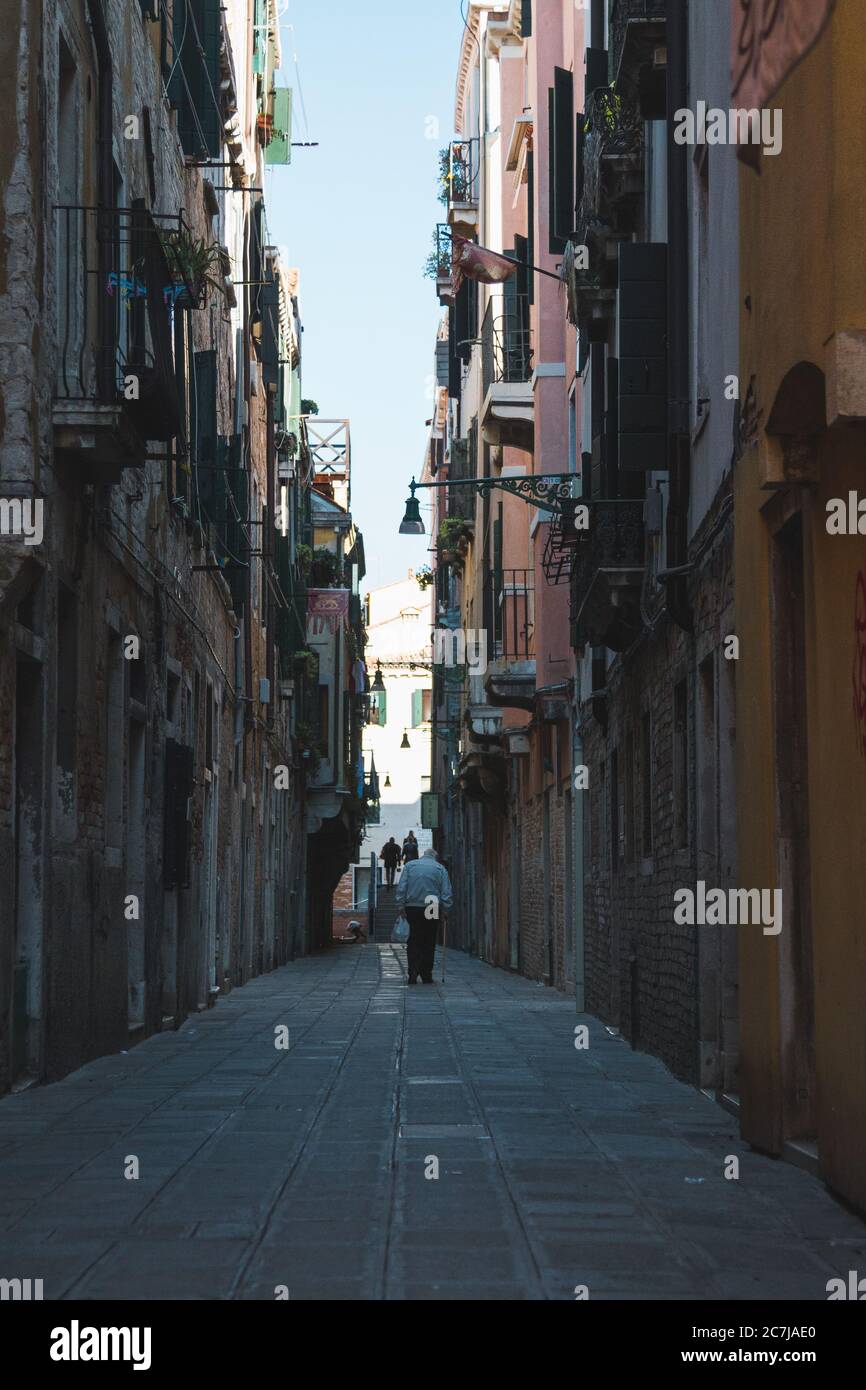 Vertical shot of a narrow alleyway in the middle of the buildings at ...
