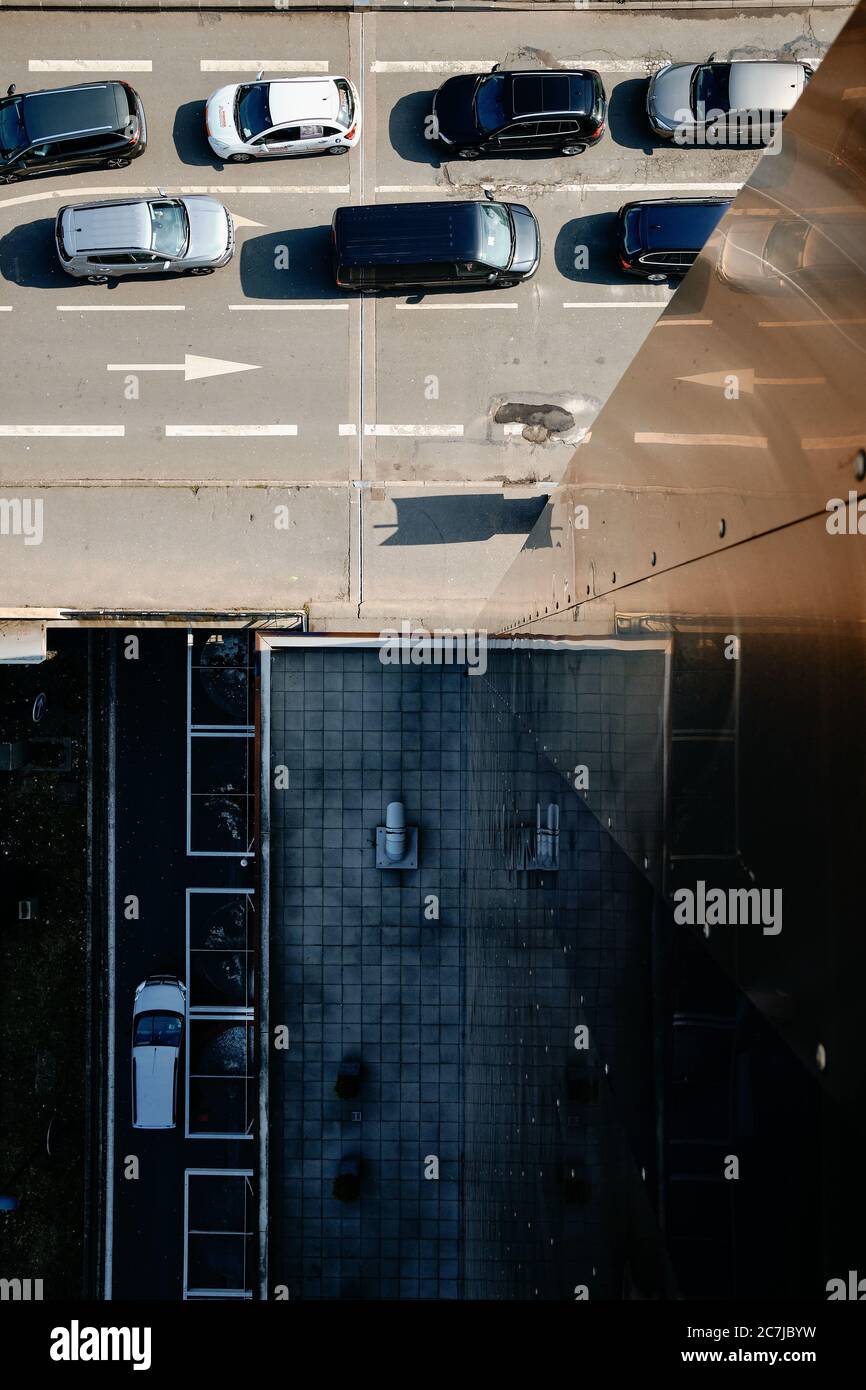 Vertical high angle shot of cars on the highway near a tall building in ...