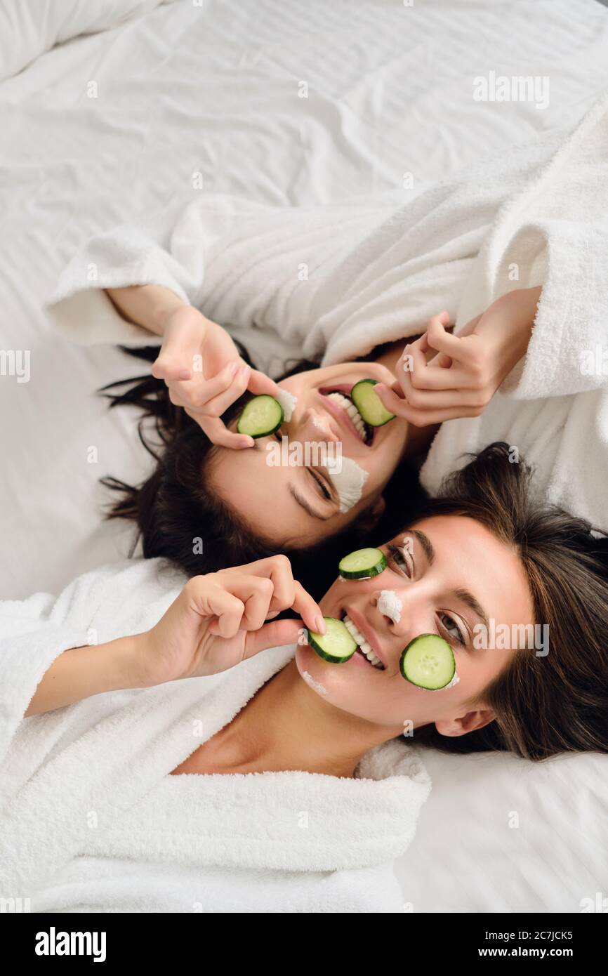 Two Young Attractive Smiling Women With Dark Hair In White Bathrobes
