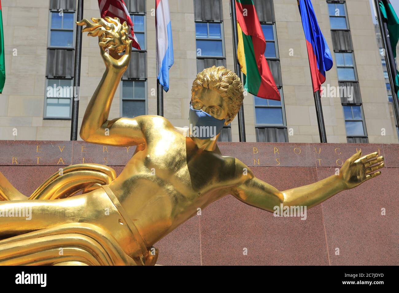 Bronze Prometheus statue, Rockefeller Center Plaza wearing face mask ...
