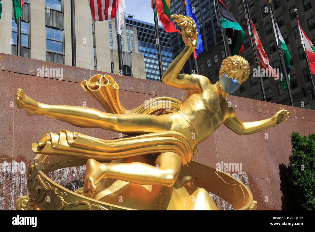 Bronze Prometheus statue, Rockefeller Center Plaza wearing face mask ...
