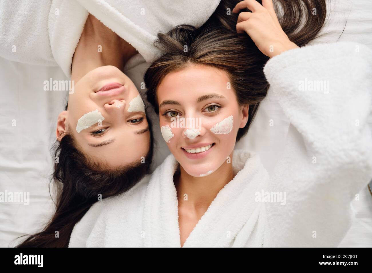 Two Young Gorgeous Smiling Women With Dark Hair In White Bathrobes