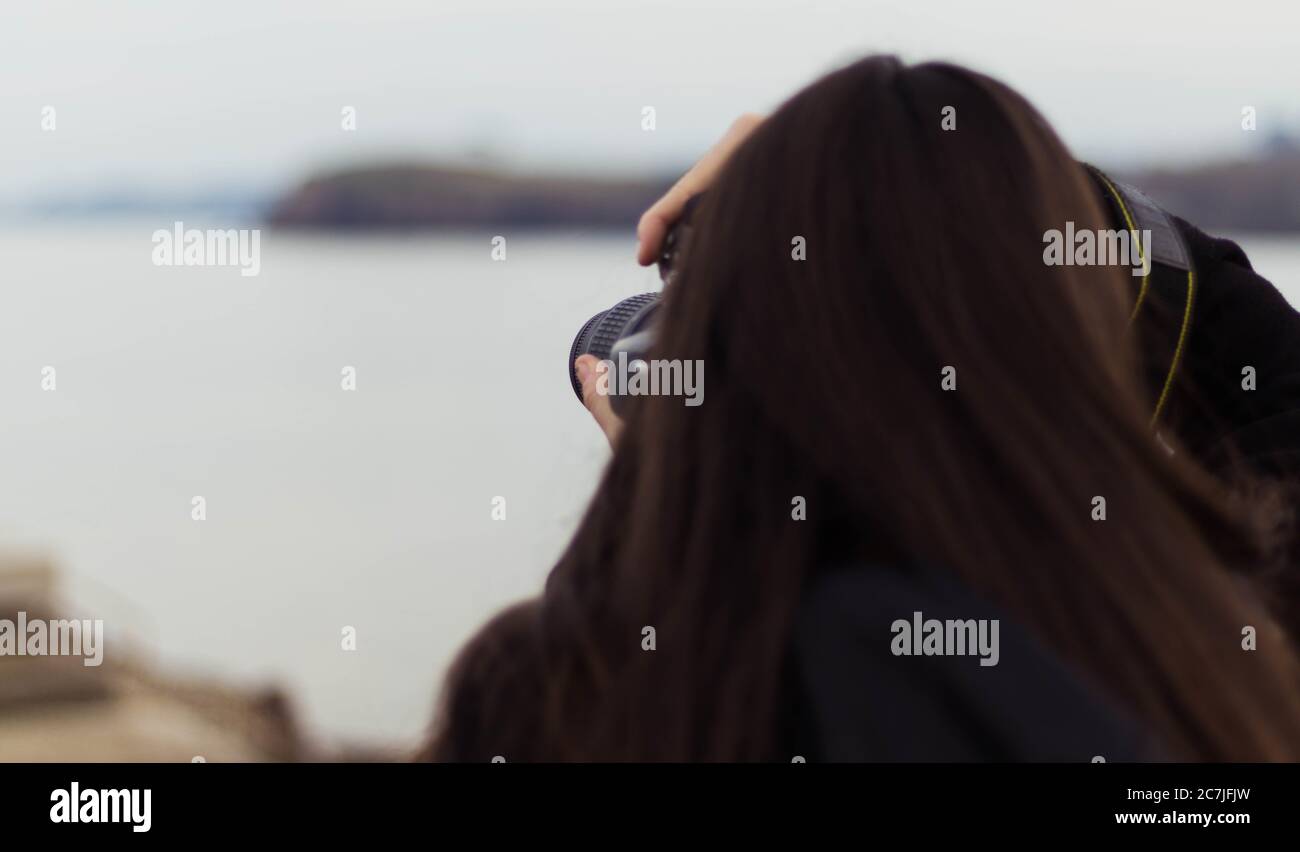 Shallow focus shot from behind of a female taking pictures Stock Photo ...