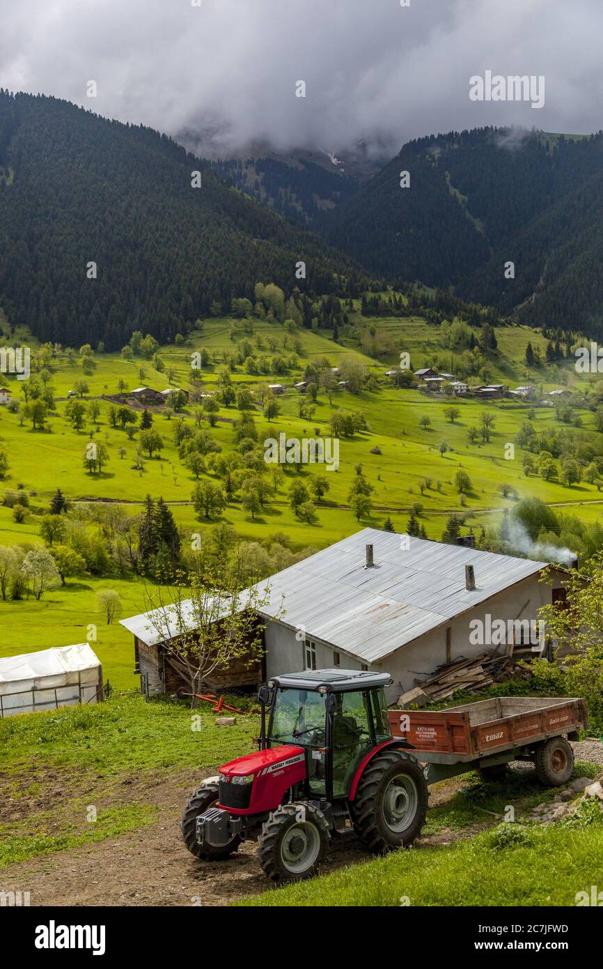 Vertical shot of the beautiful village and a tractor captured in ...